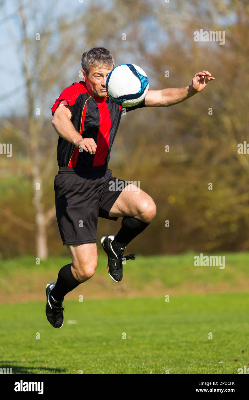 Soccer player with ball on field Stock Photo - Alamy