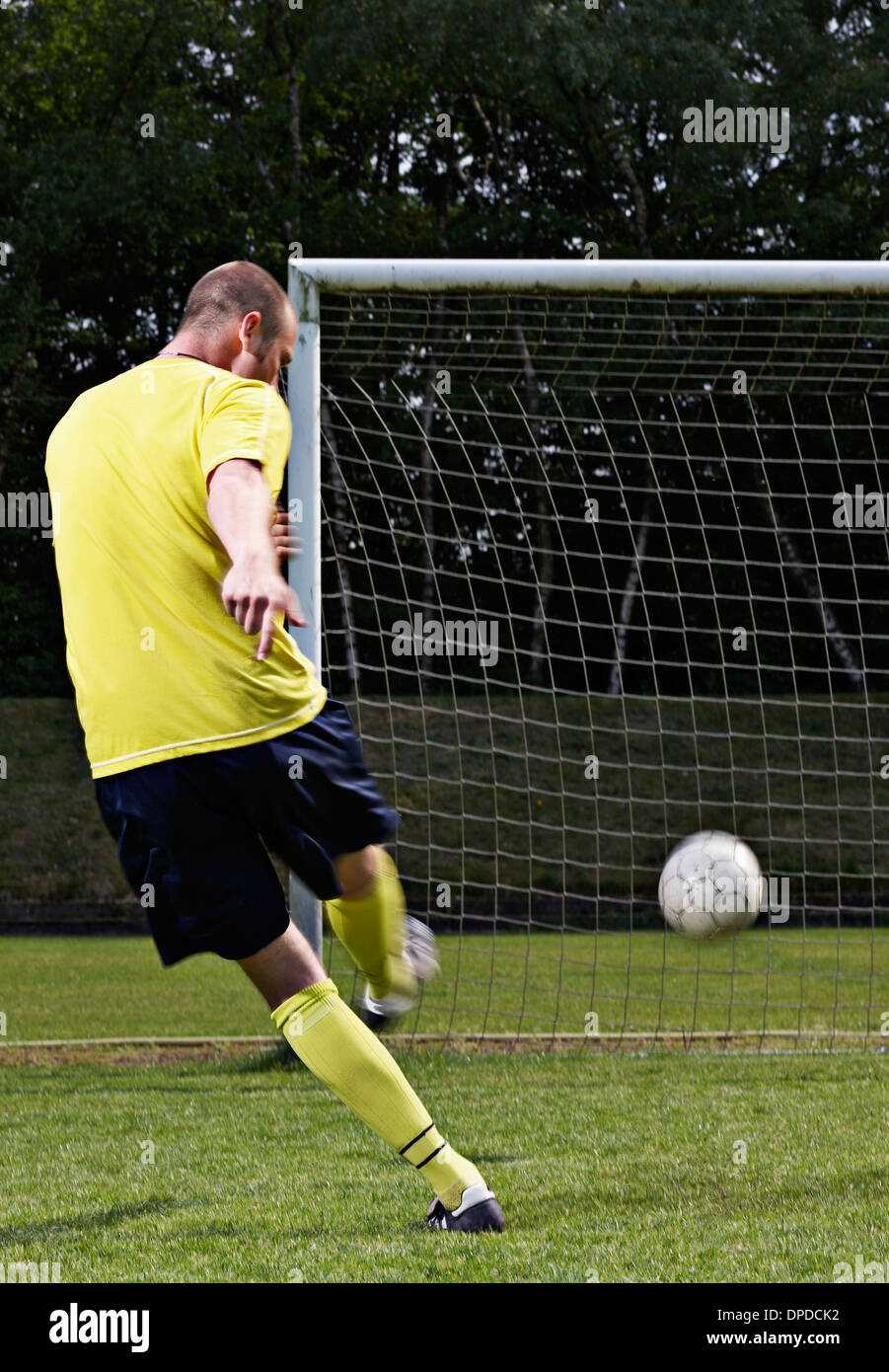 Soccer player scoring a goal Stock Photo - Alamy