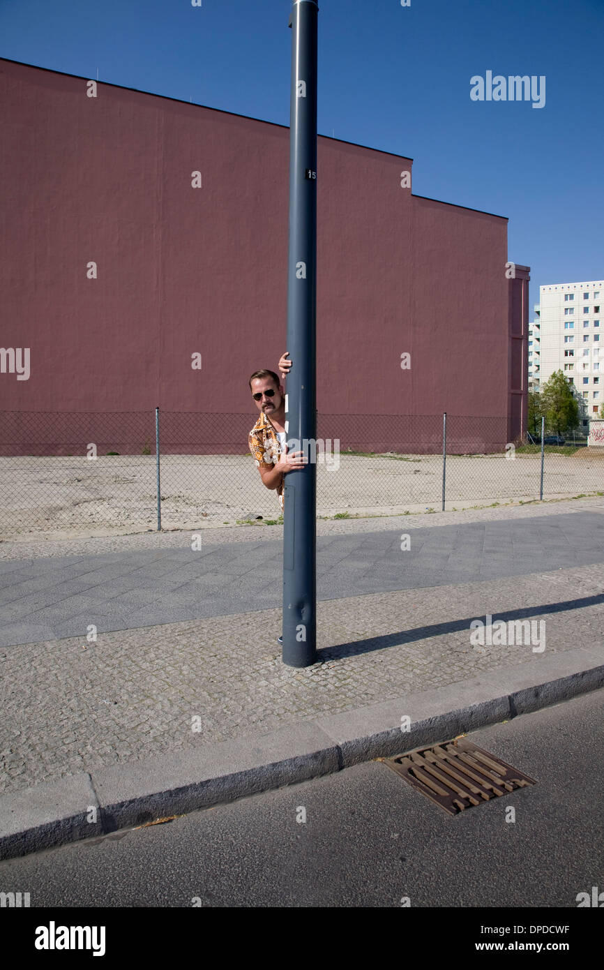 Man peeking out behind lamp pole hi-res stock photography and images ...