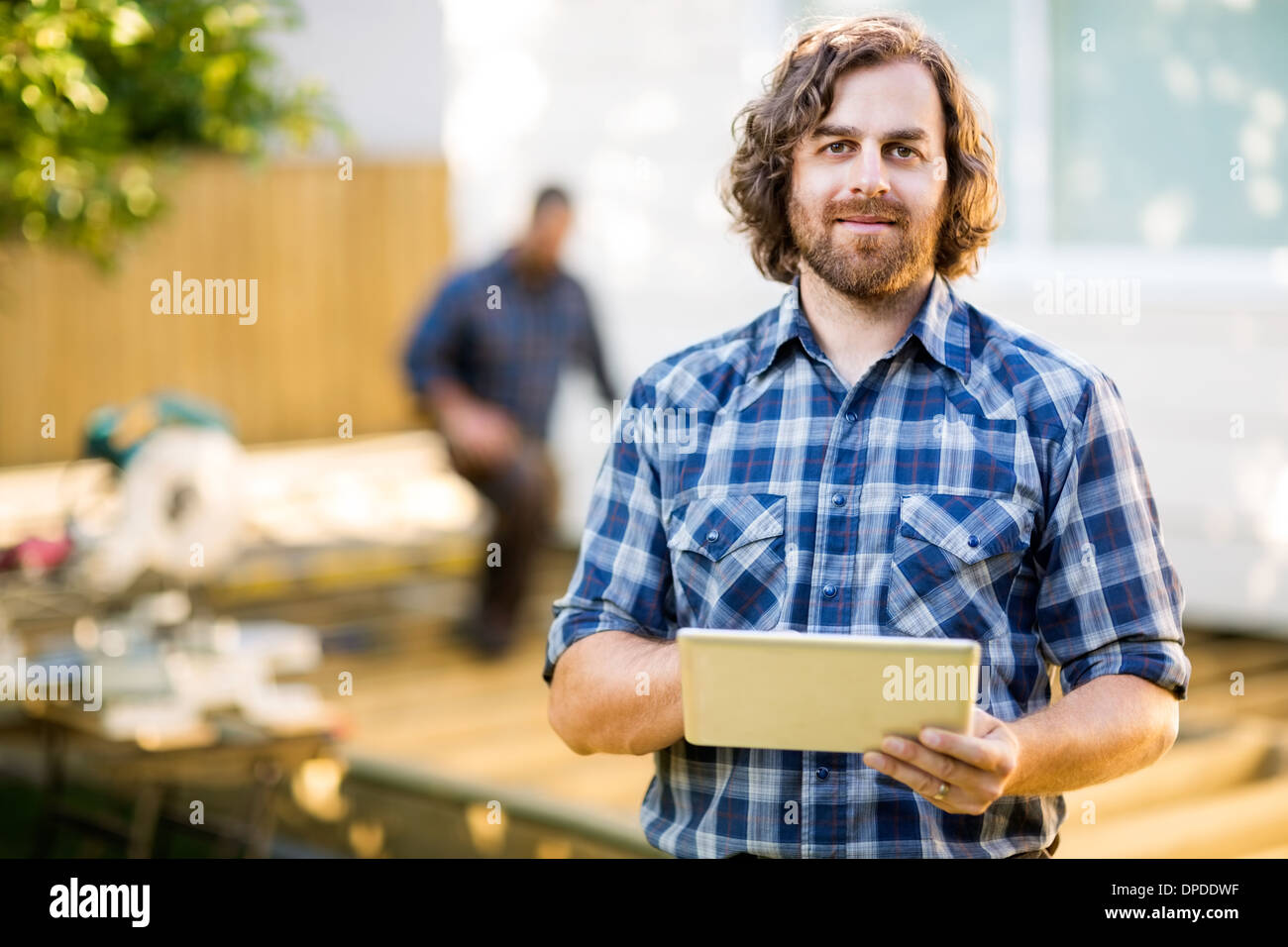 Manual Worker Holding Digital Tablet With Coworker Working In Ba Stock ...