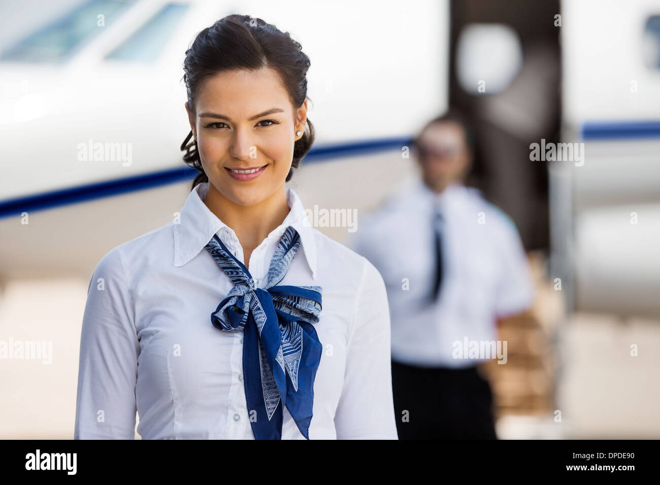Pretty Stewardesses Smiling With Pilot And Private Jet In Backgr Stock ...
