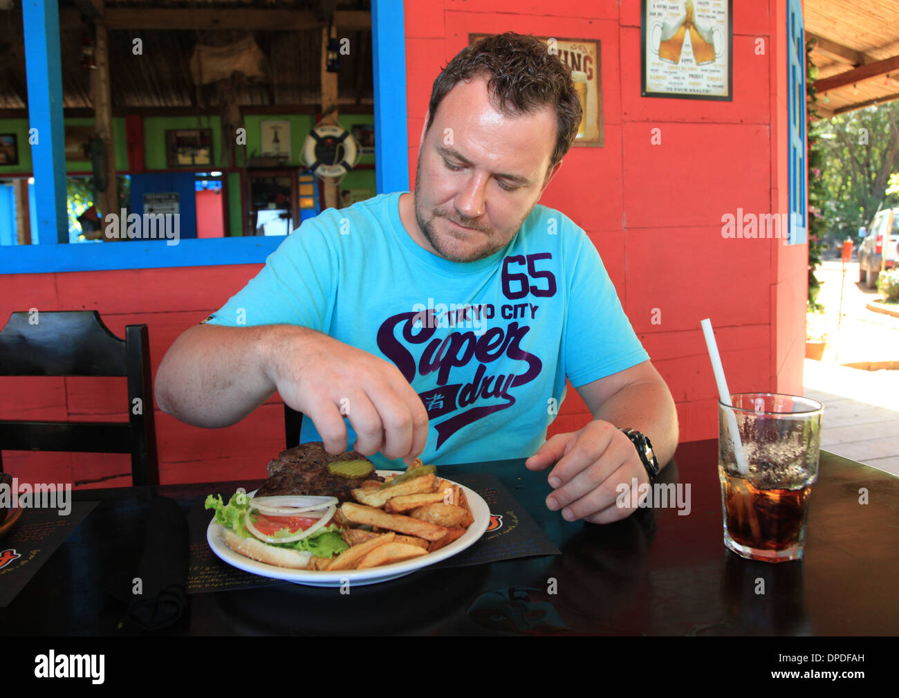Young man eating food Stock Photo - Alamy