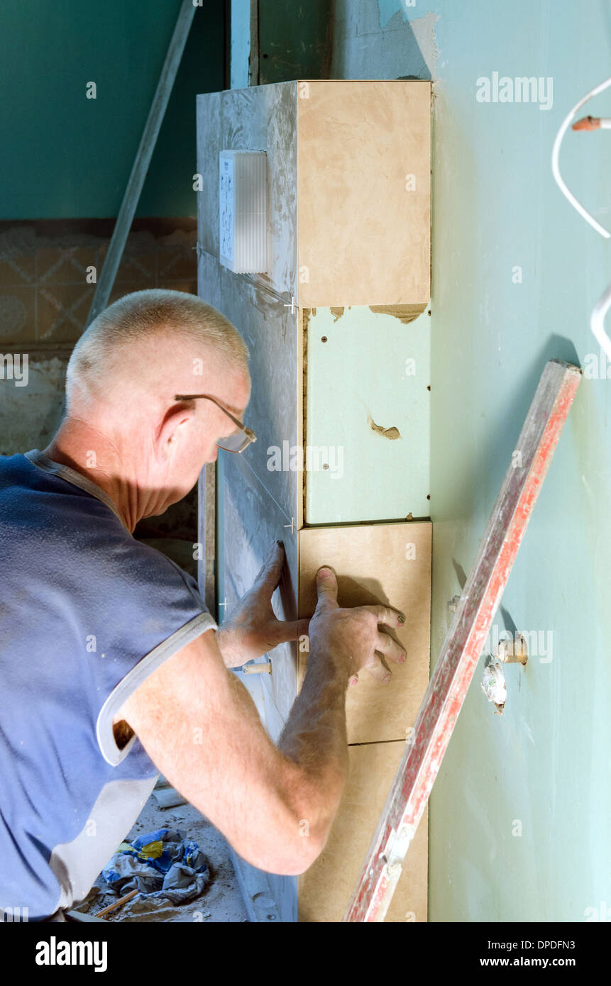 Worker fixing tiles on the wall Stock Photo - Alamy