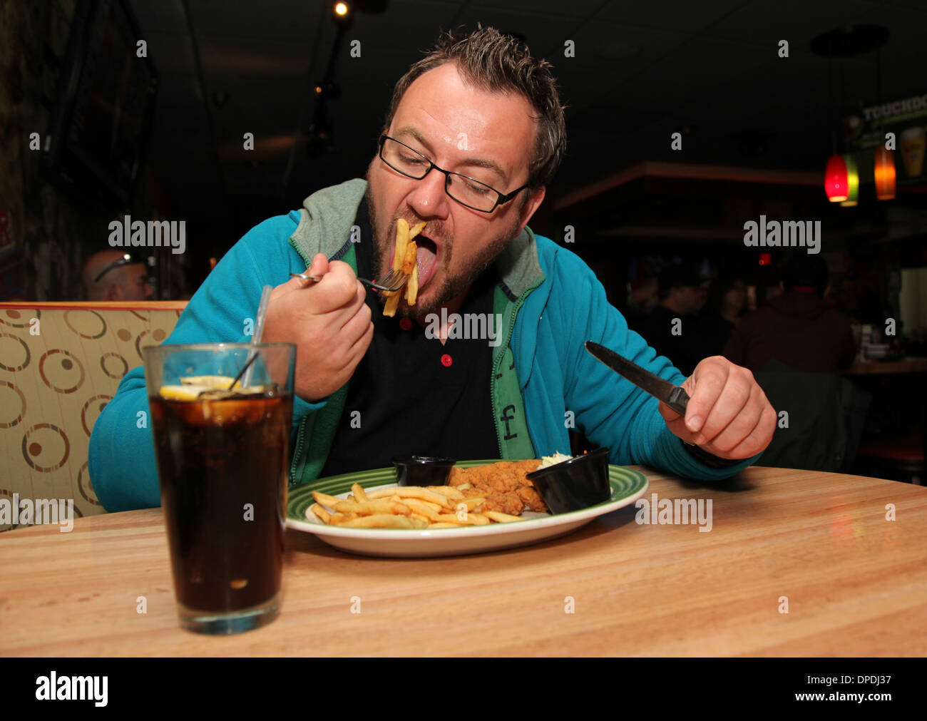 Young man eating food Stock Photo - Alamy