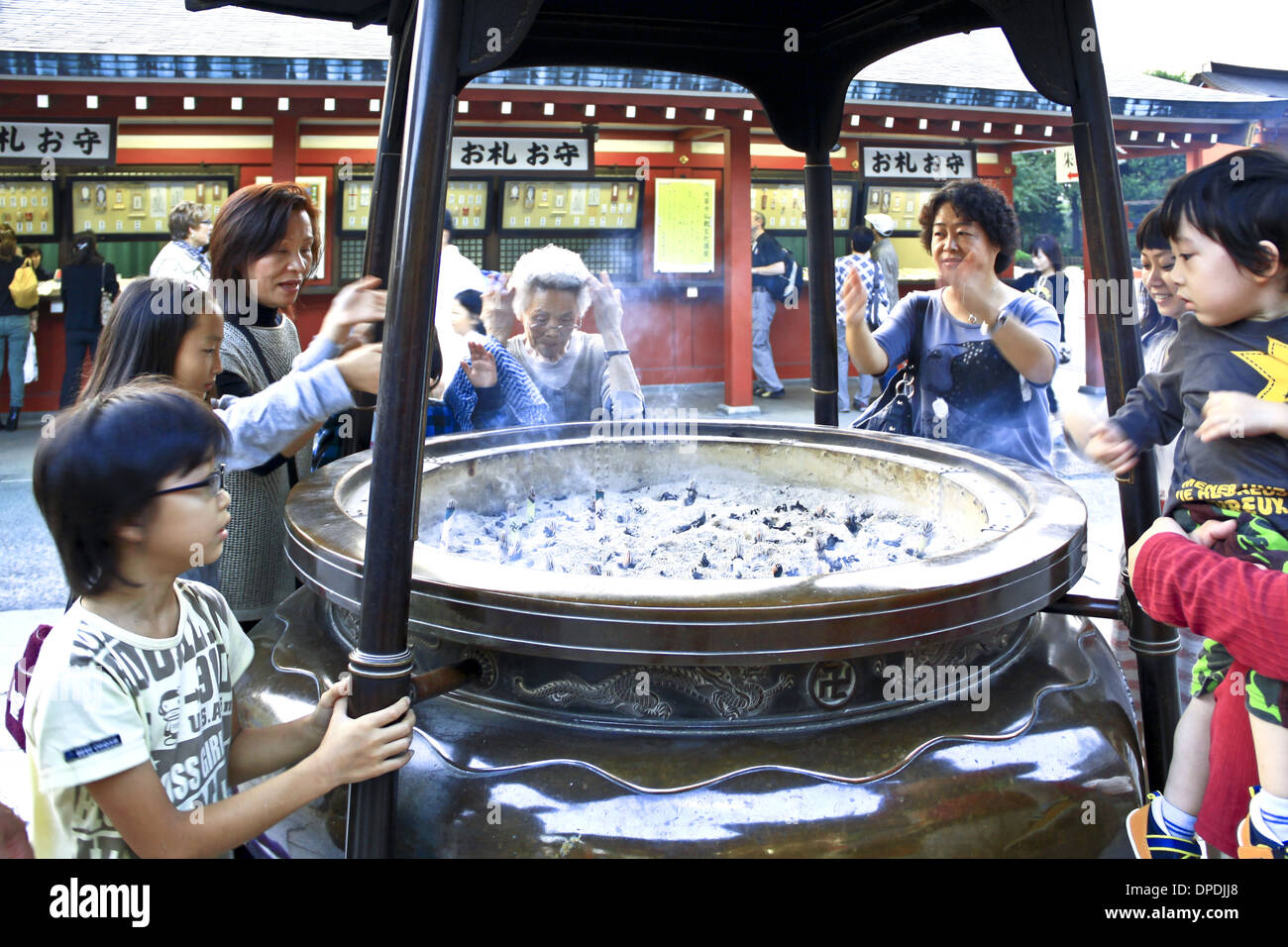 Huge censer surrounded by people, who are wafting incense fumes to stay ...