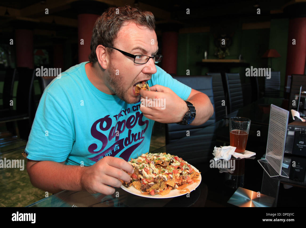 Young man eating food Stock Photo - Alamy