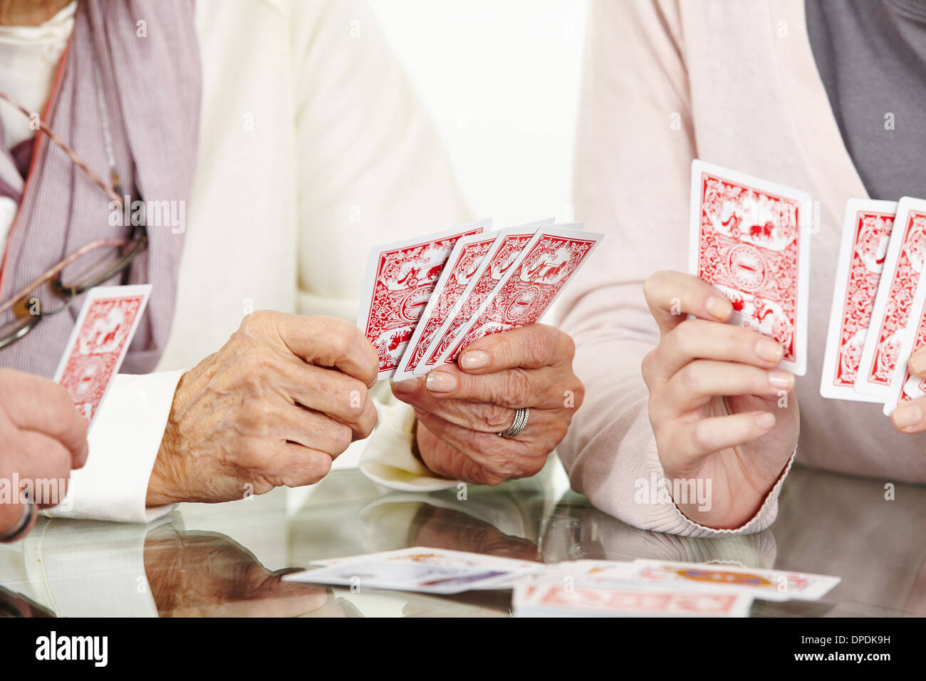 Many hands of senior adults playing cards together Stock Photo - Alamy