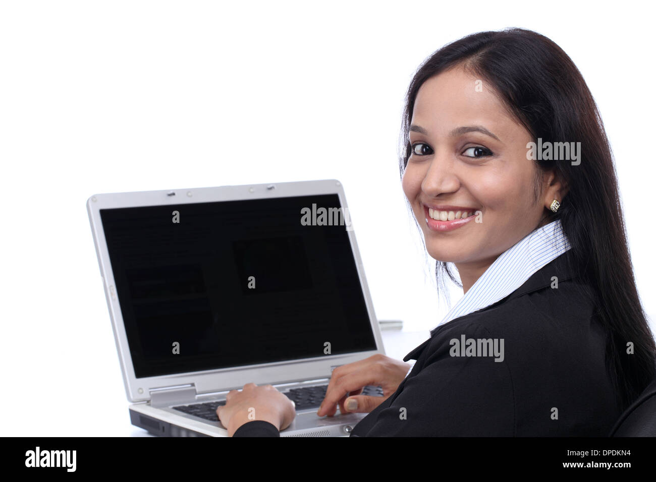 Smiling young business woman working with laptop against white Stock ...