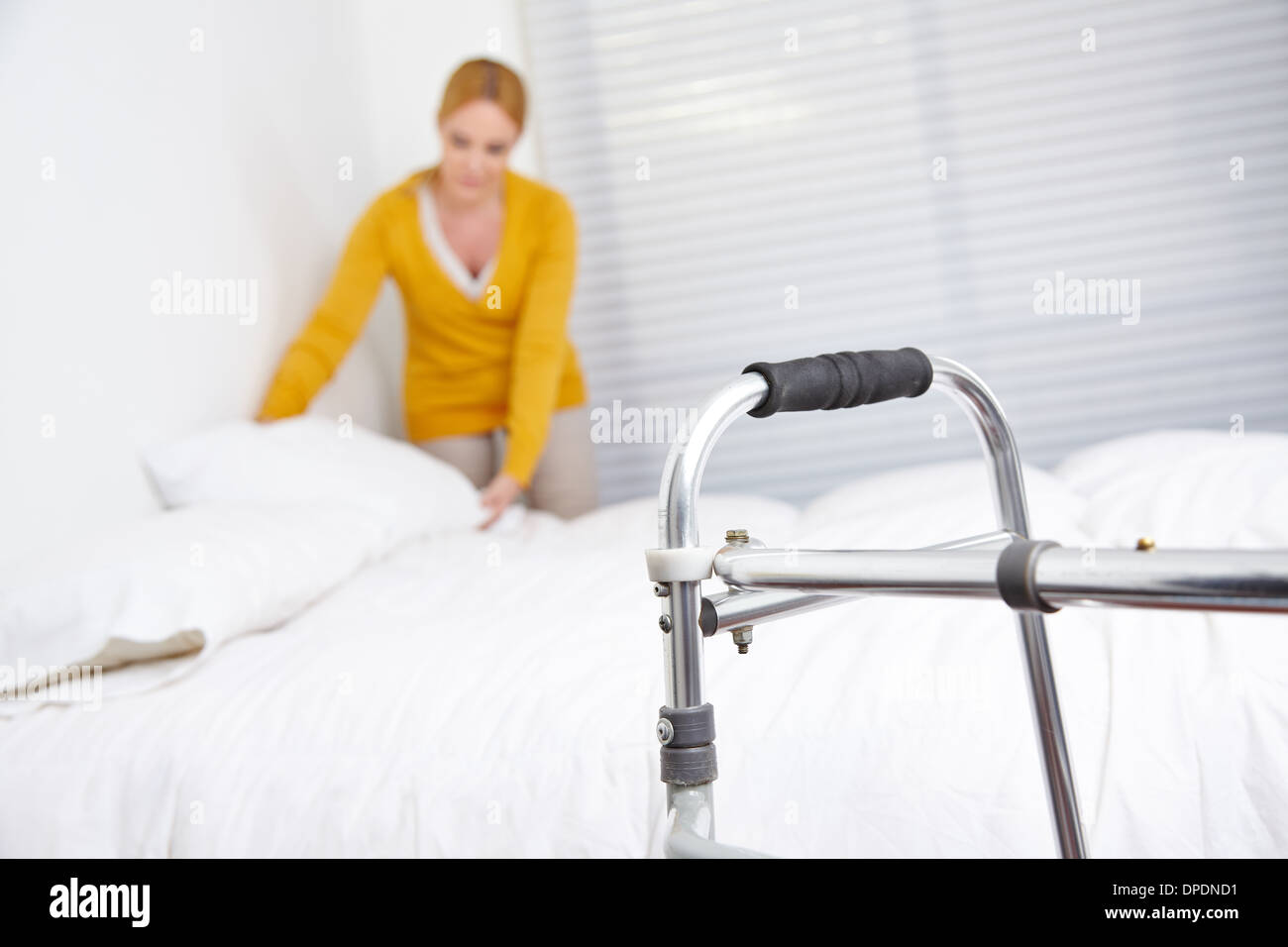 Cleaning lady doing housekeeping in nursing home with walker in front ...