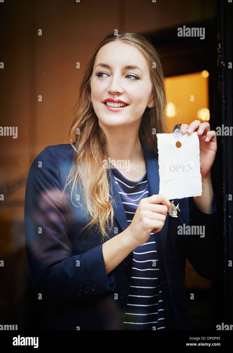 Shop owner with open sign Stock Photo - Alamy