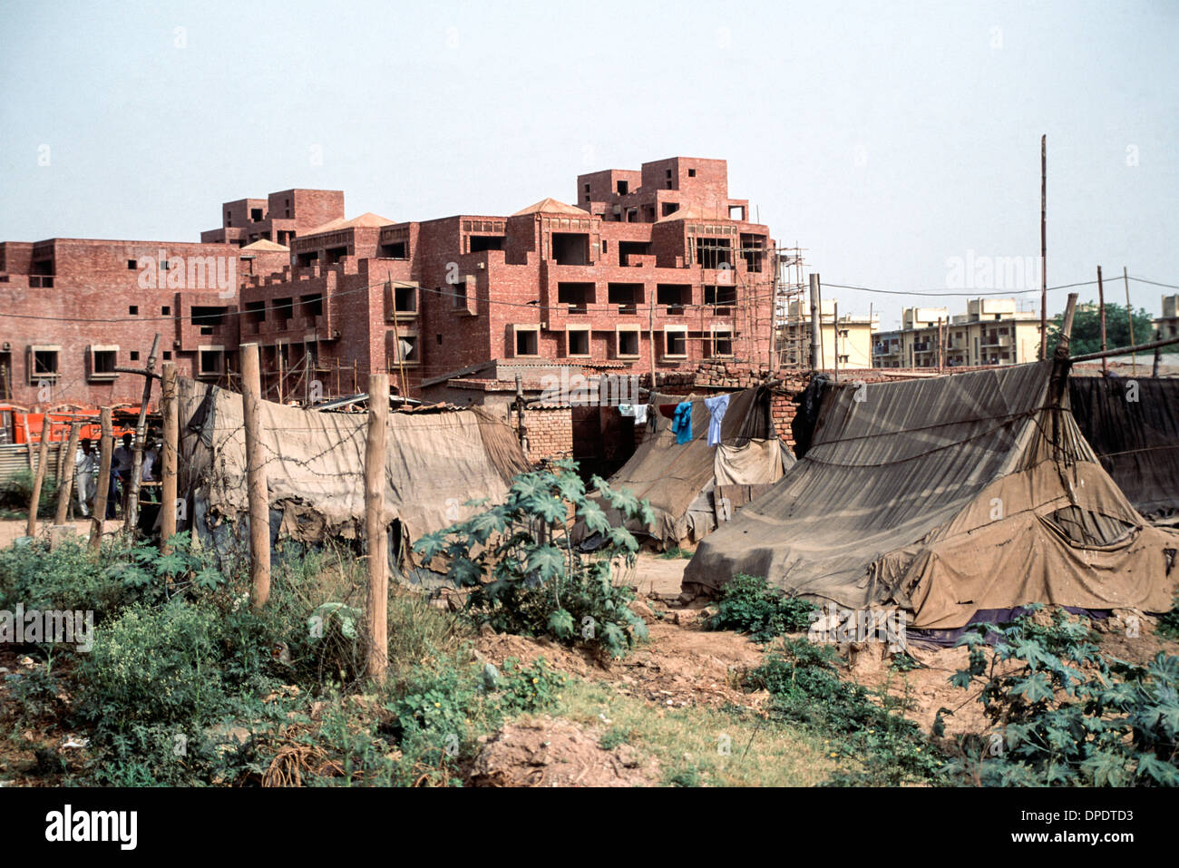 Shanty town of makeshift tents outside a half-finished construction ...