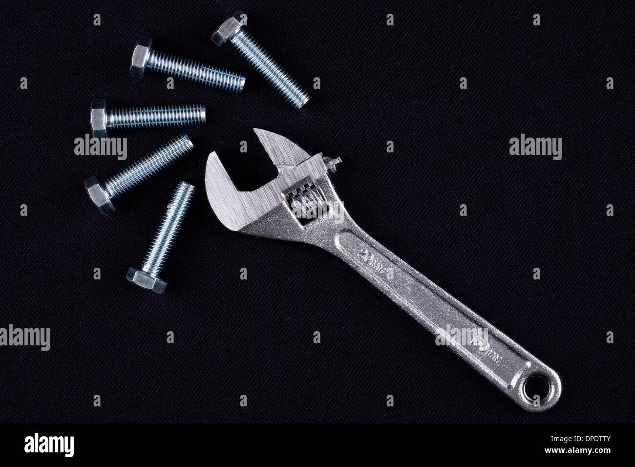 Adjustable wrench and screws on black background Stock Photo - Alamy