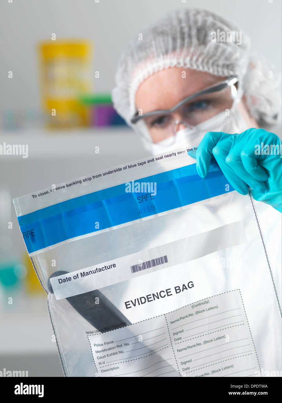 Forensic scientist holding evidence bag from crime scene in laboratory ...