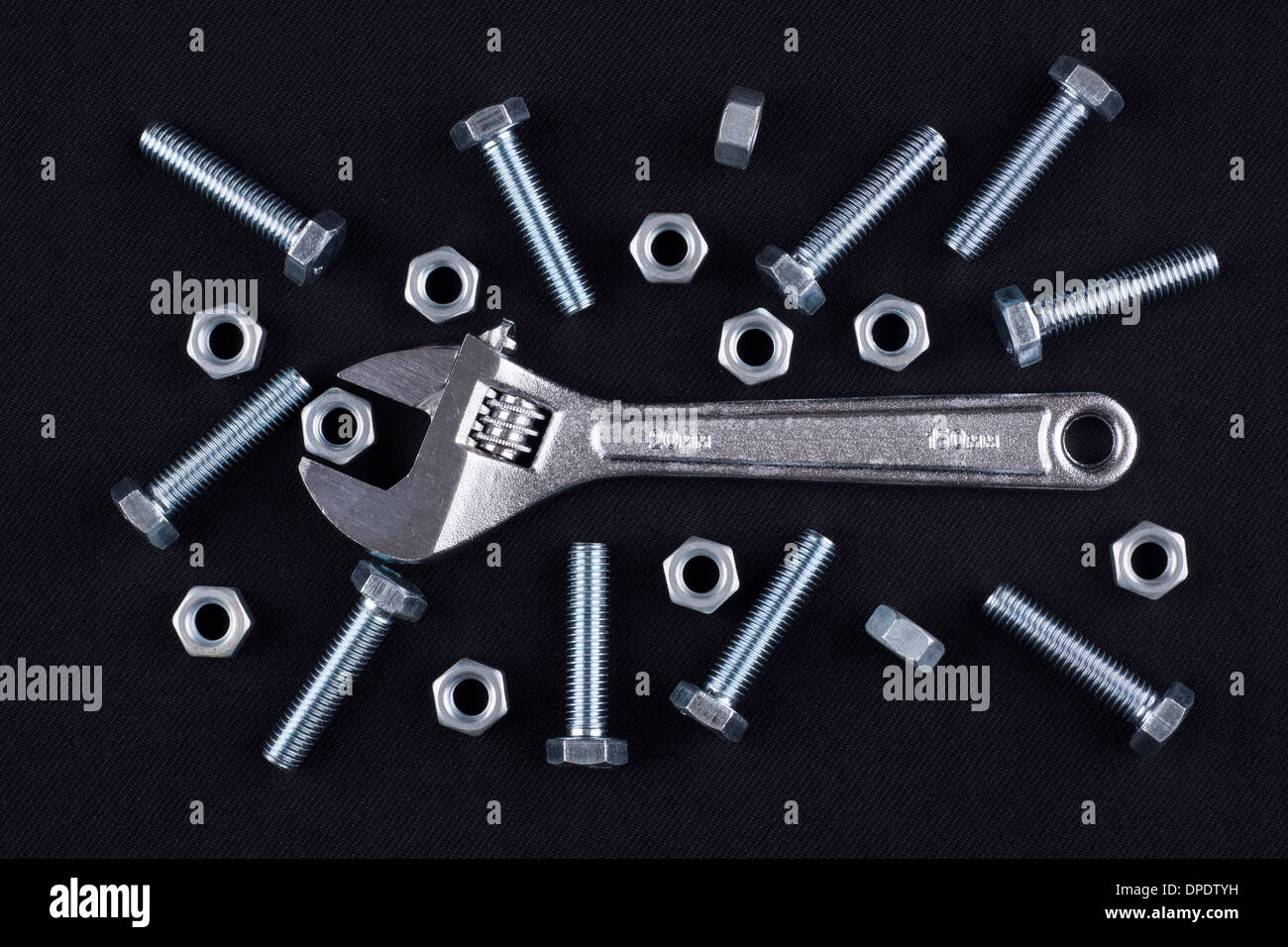 Adjustable wrench with screws and nuts on black background Stock Photo ...