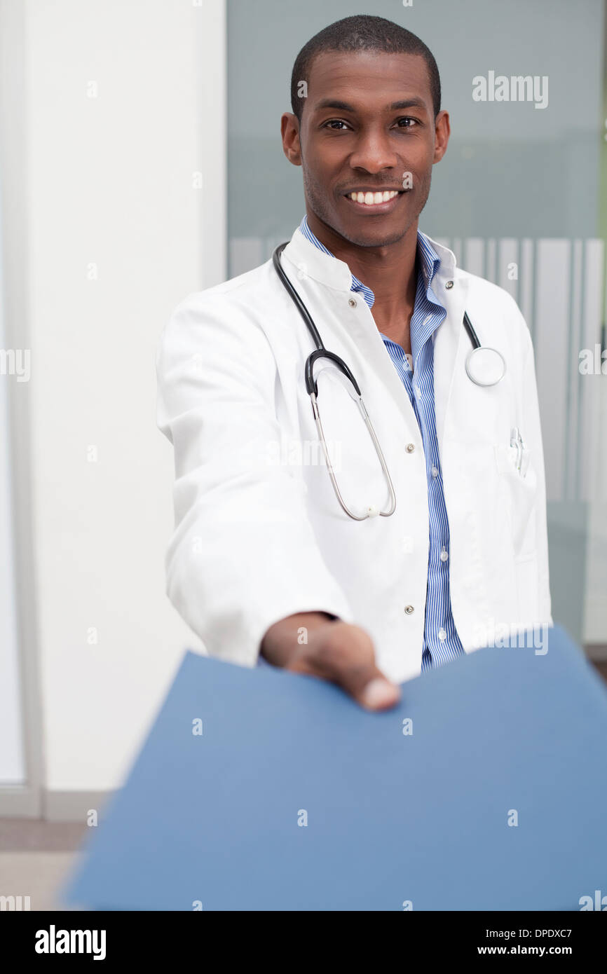 Doctor handing over paperwork Stock Photo - Alamy