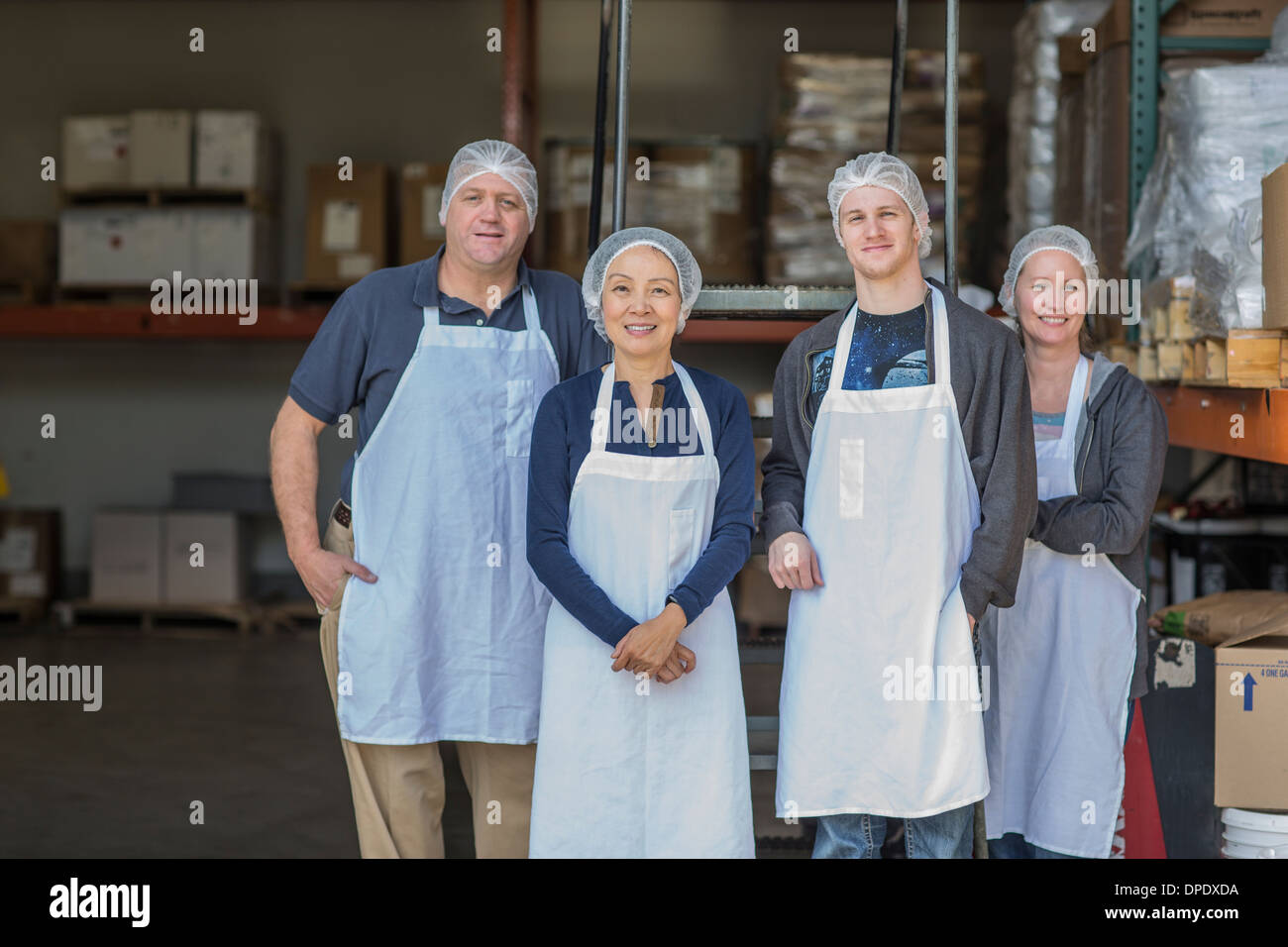 Portrait of four factory workers smiling Stock Photo - Alamy