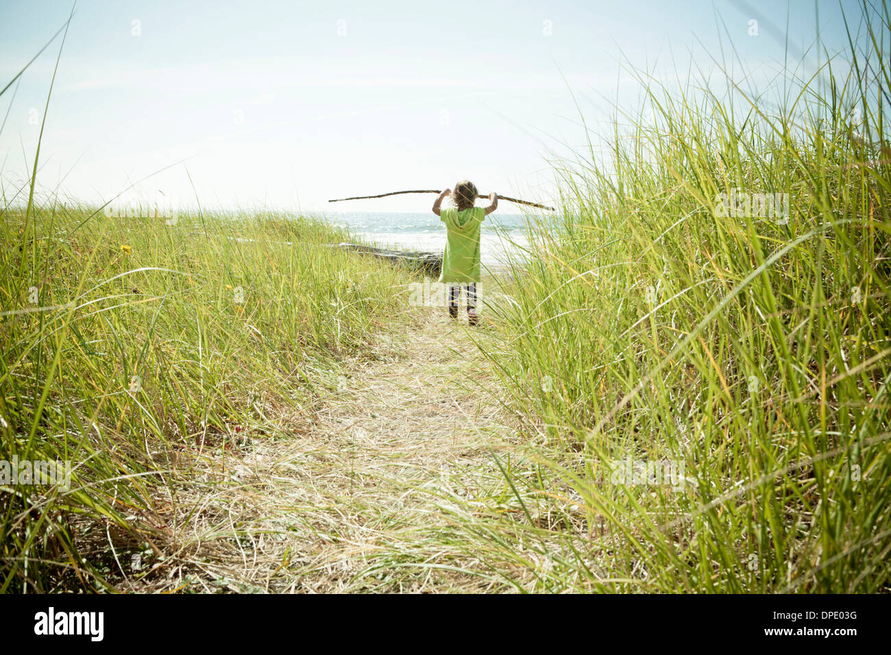 Female toddler carrying long stick Stock Photo - Alamy