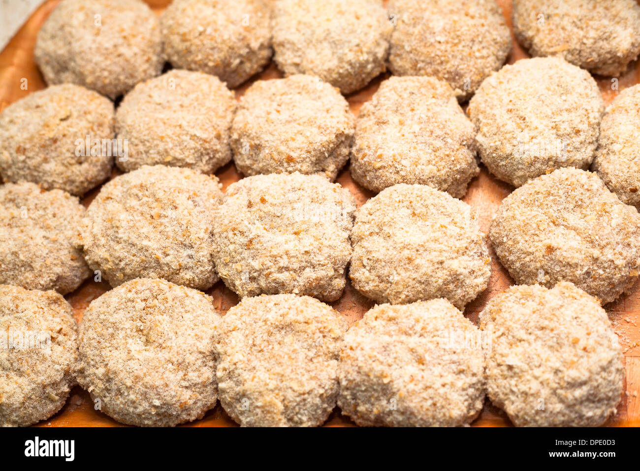 Many breaded burgers ready to cook Stock Photo - Alamy