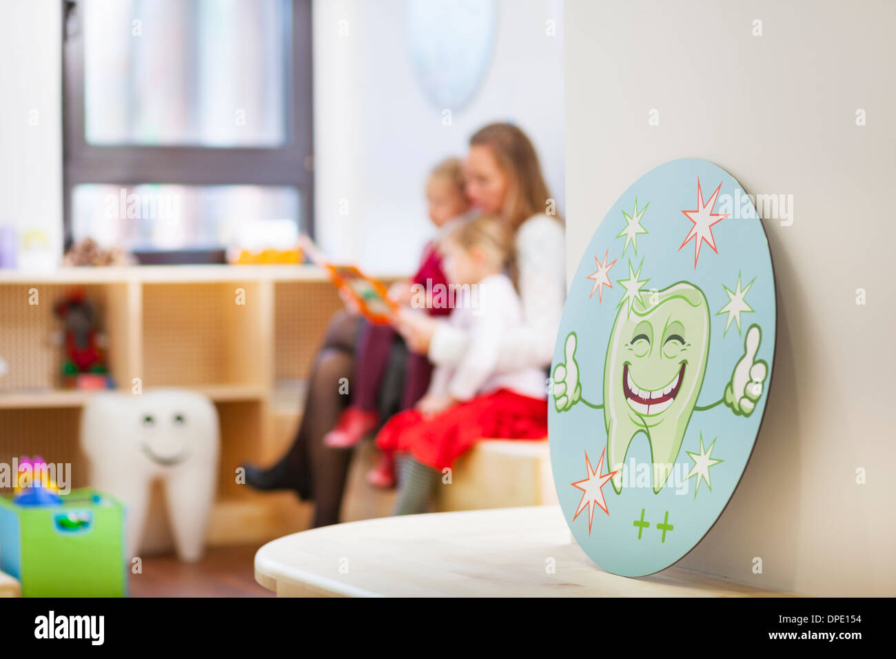 Family in dentists waiting room, picture of tooth in foreground Stock ...