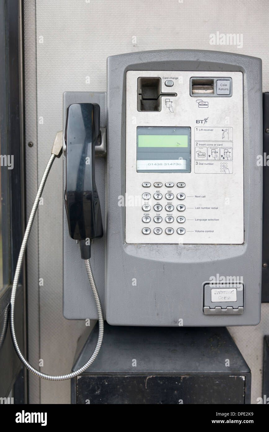 A public telephone kiosk showing the handset and dialing buttons in the ...