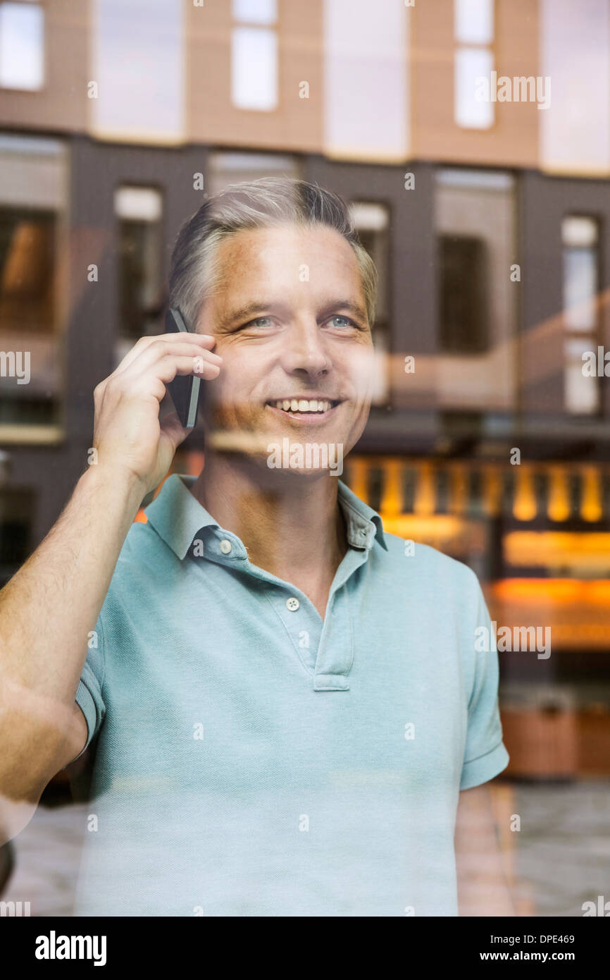 Businessmen making phone call, view through window Stock Photo - Alamy