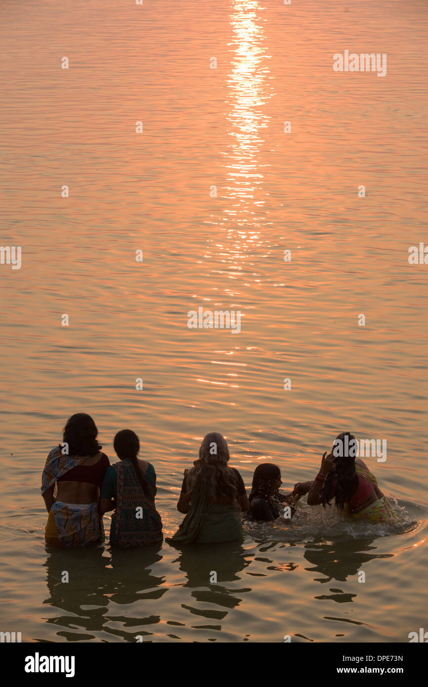Group of female pilgrims bathing in the River Ganges at sunrise ...