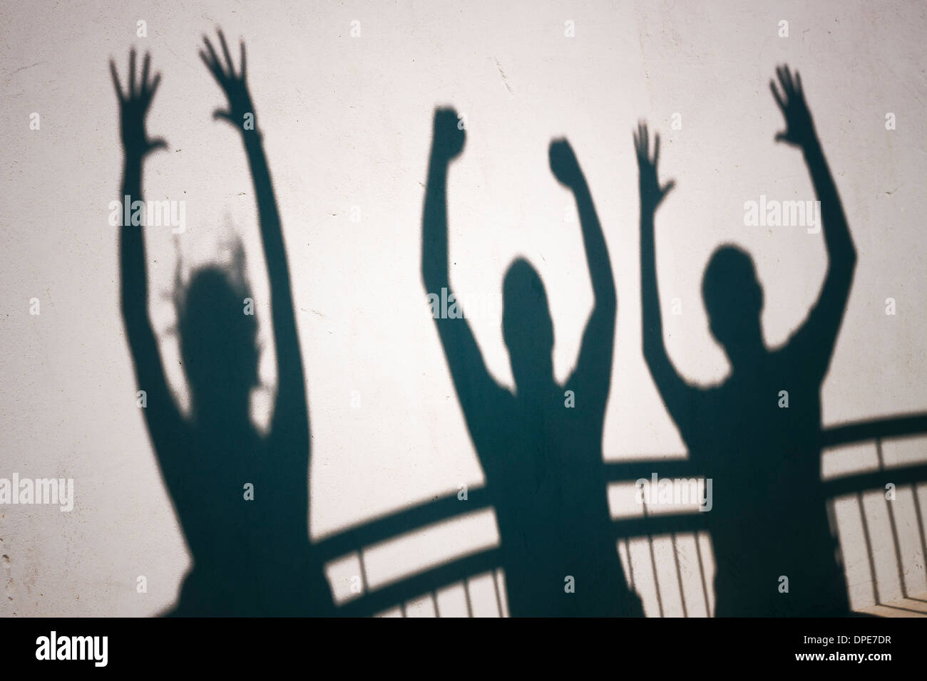 Creative photo of ecstatic people shadows on white wall Stock Photo - Alamy