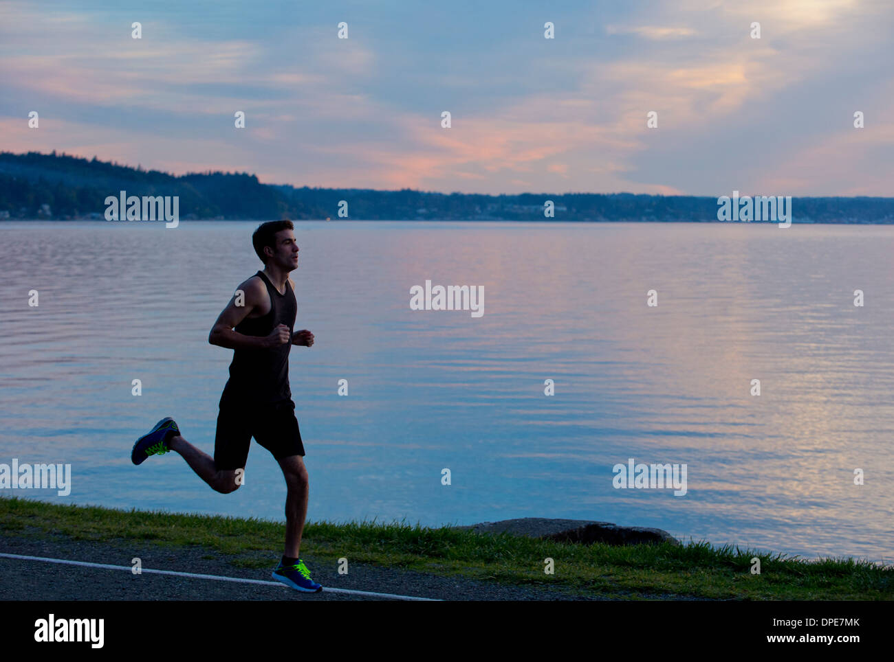 Jogger running past lake Stock Photo - Alamy