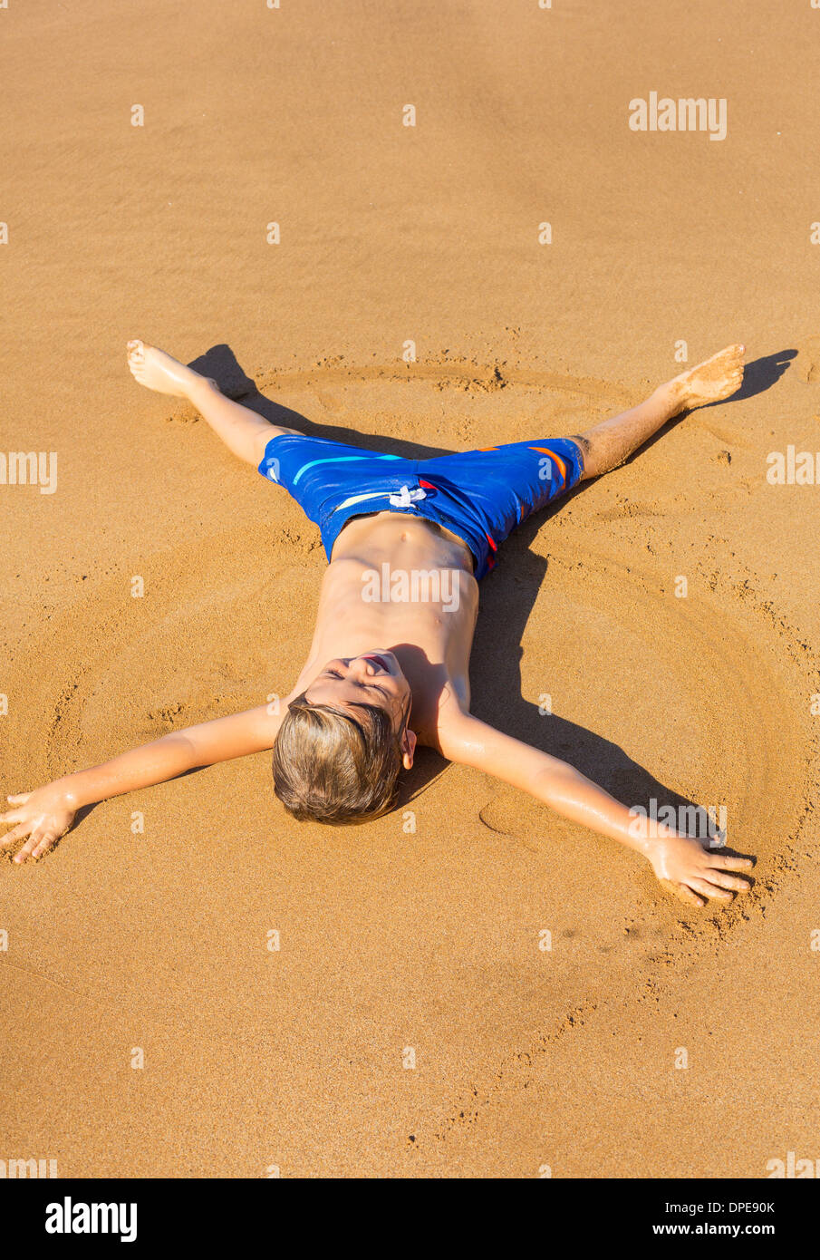 Child laying in sand hi-res stock photography and images - Alamy