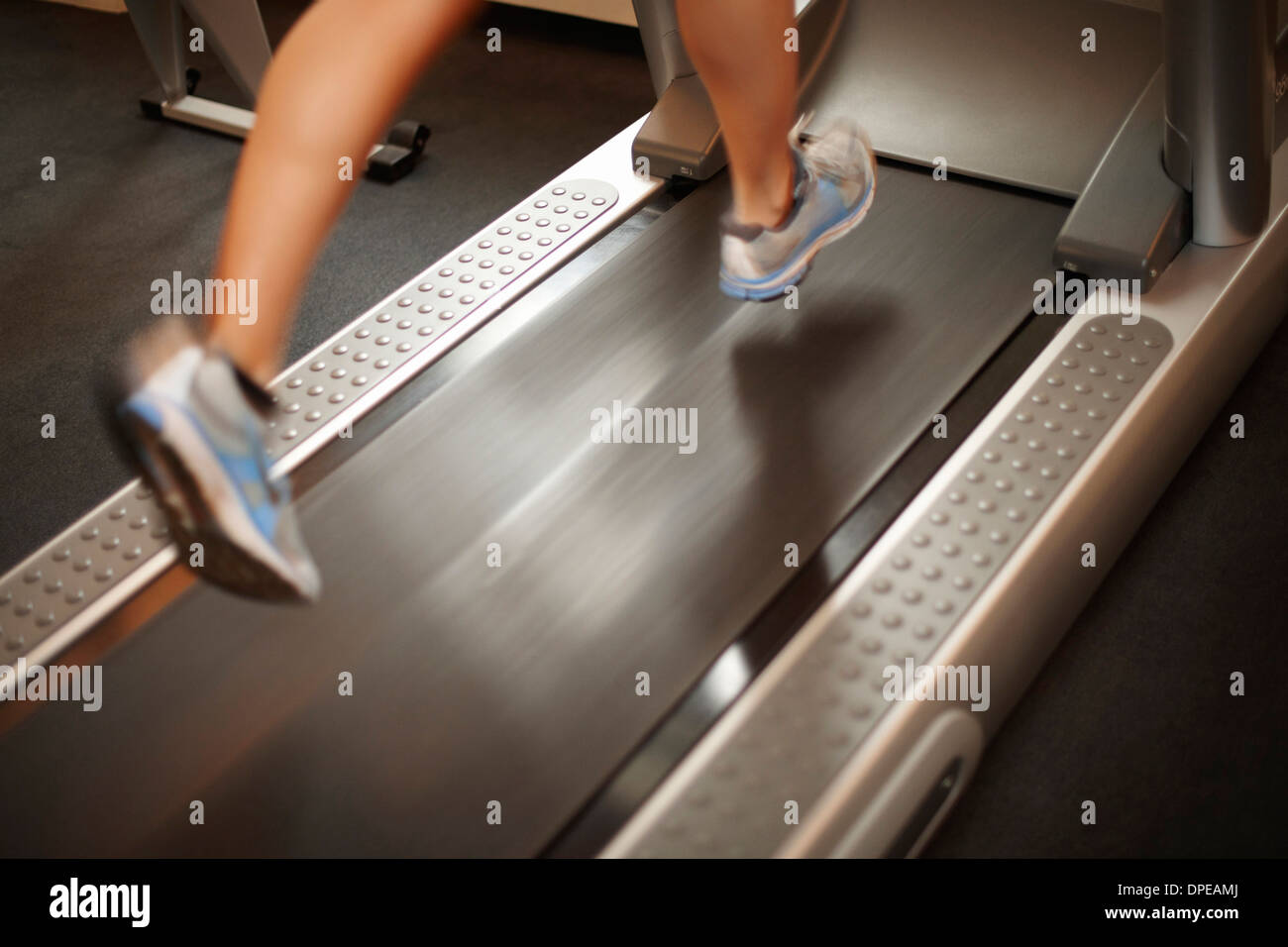 Woman running on treadmill Stock Photo - Alamy