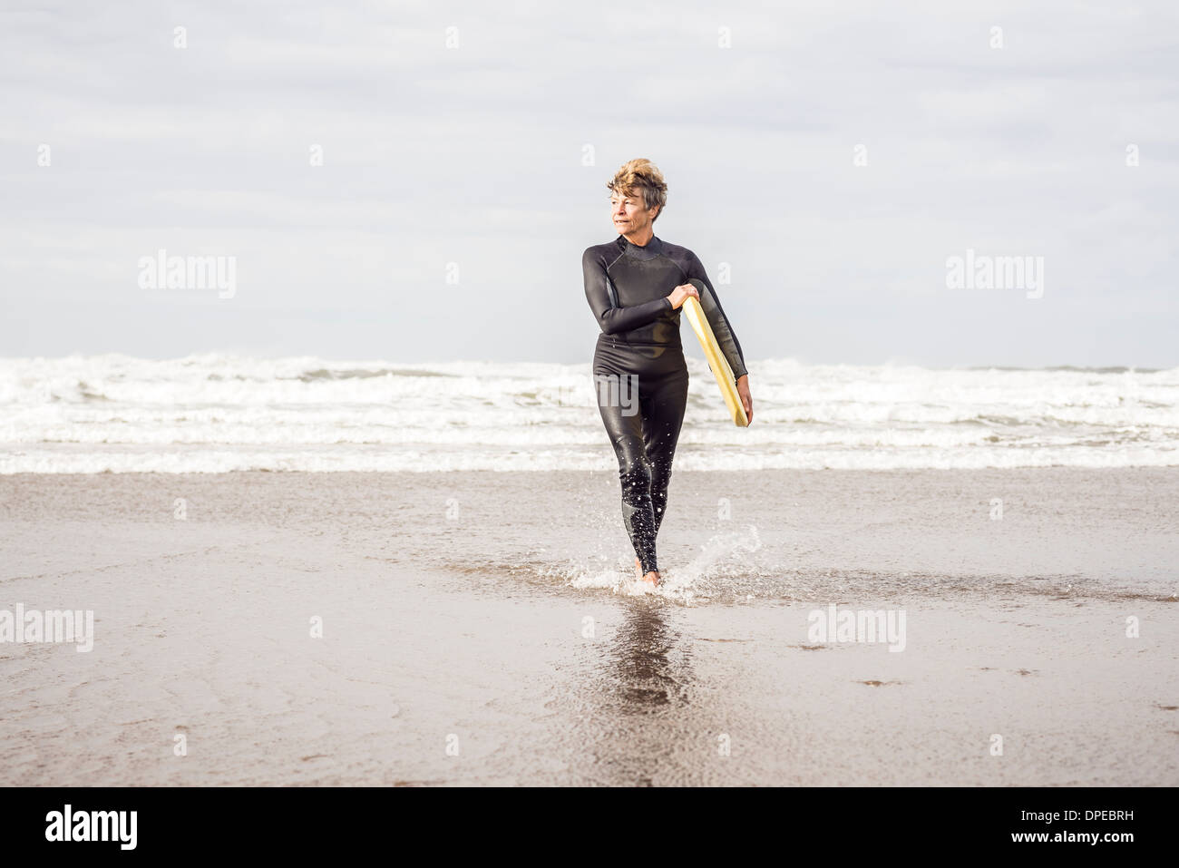 Mature female bodyboarder paddling on Devon coast, UK Stock Photo - Alamy