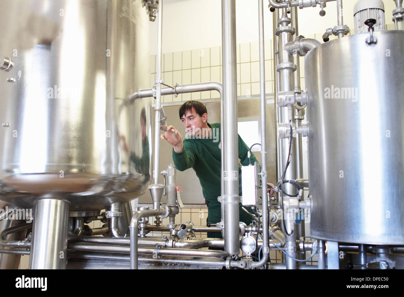 Brewery worker operating machine Stock Photo - Alamy