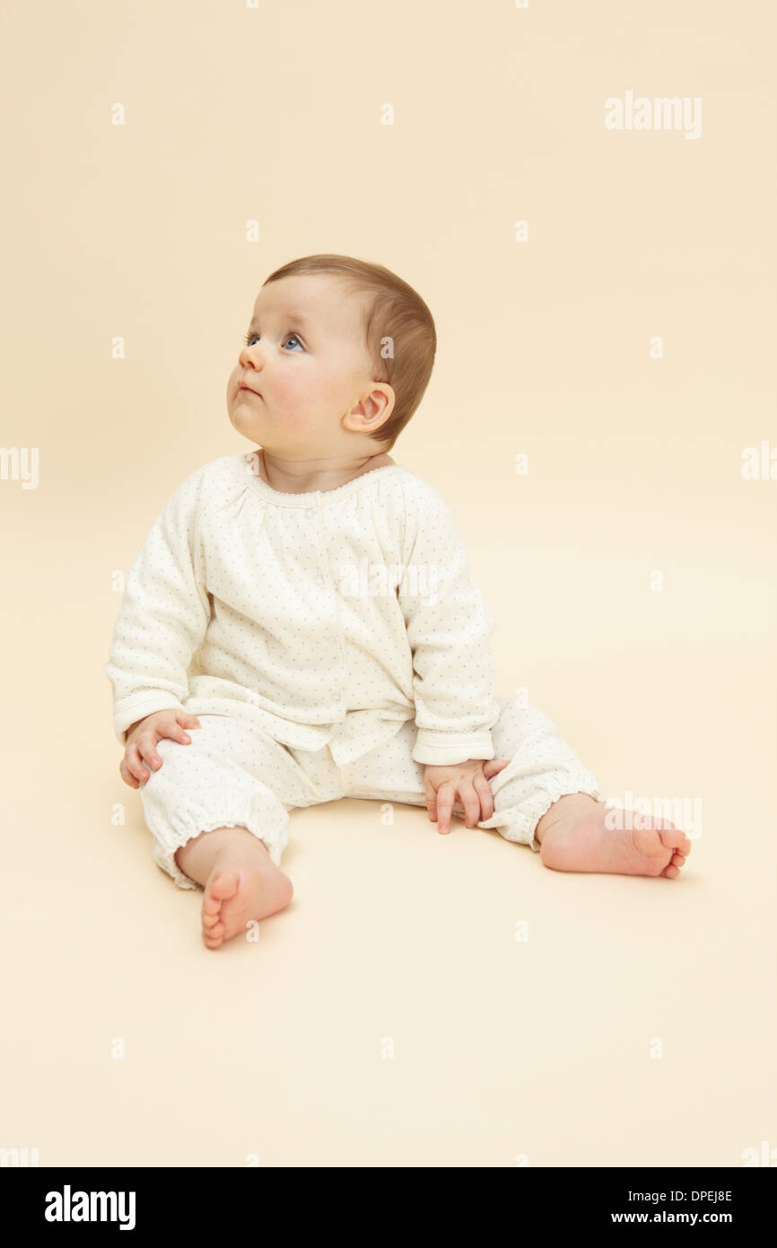 Studio portrait of distracted baby girl Stock Photo - Alamy