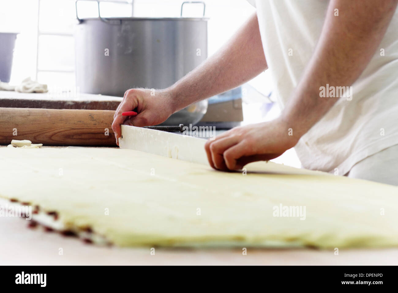 Baker cutting dough Stock Photo - Alamy
