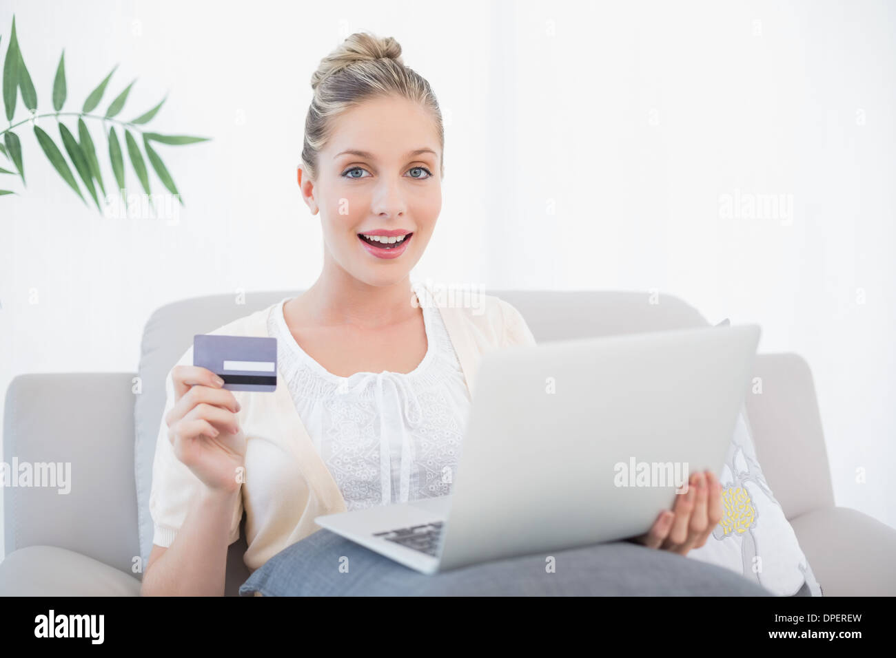 Surprised fresh model shopping online using laptop Stock Photo - Alamy