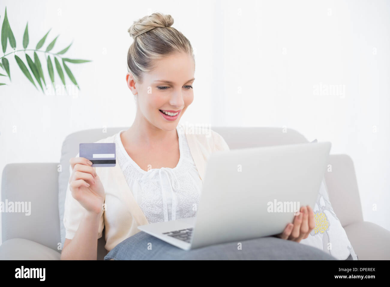 Smiling fresh model shopping online using laptop Stock Photo - Alamy
