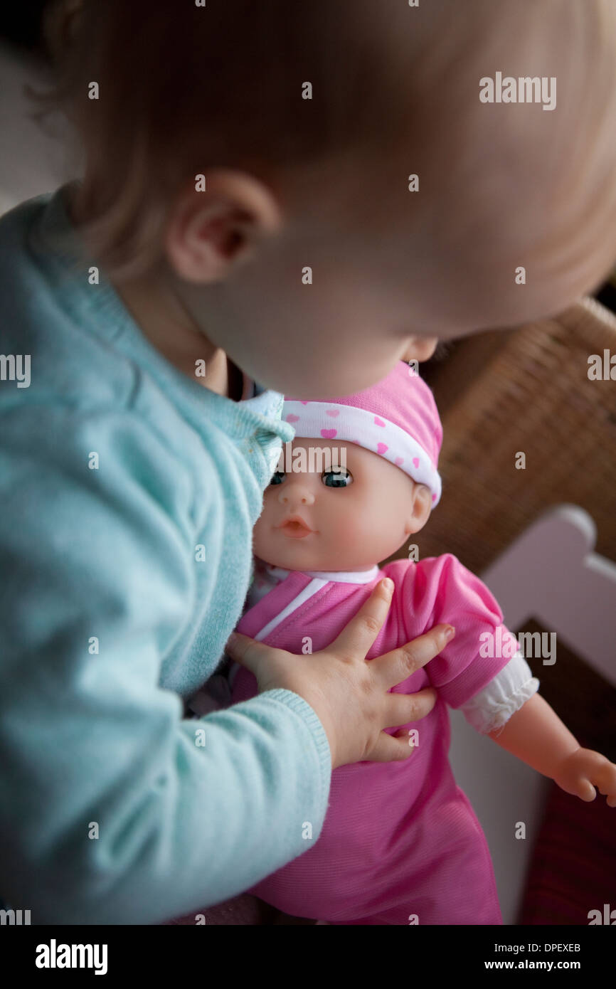 Toddler playing with a doll Stock Photo - Alamy