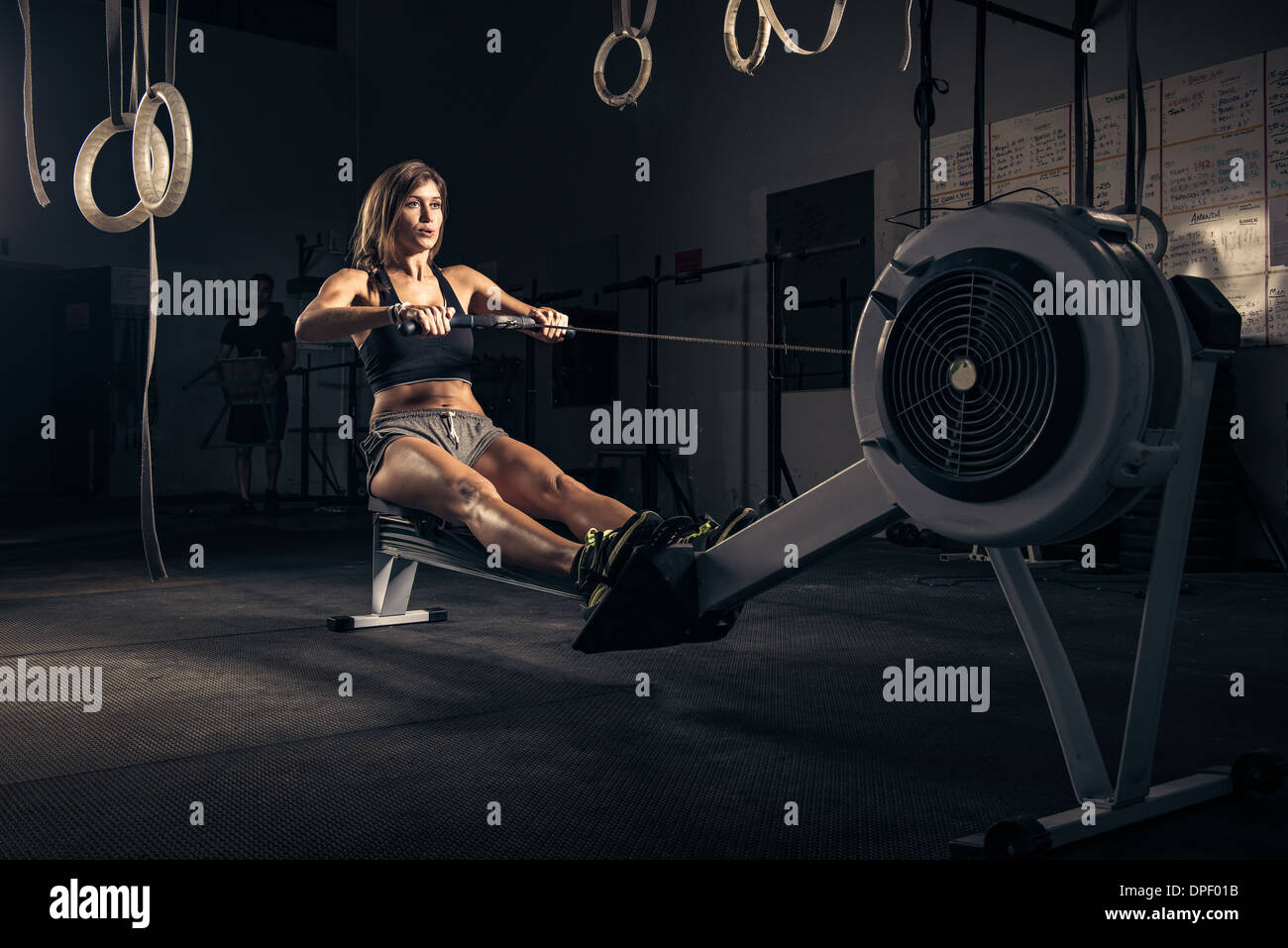Woman using rowing machine in gym Stock Photo - Alamy