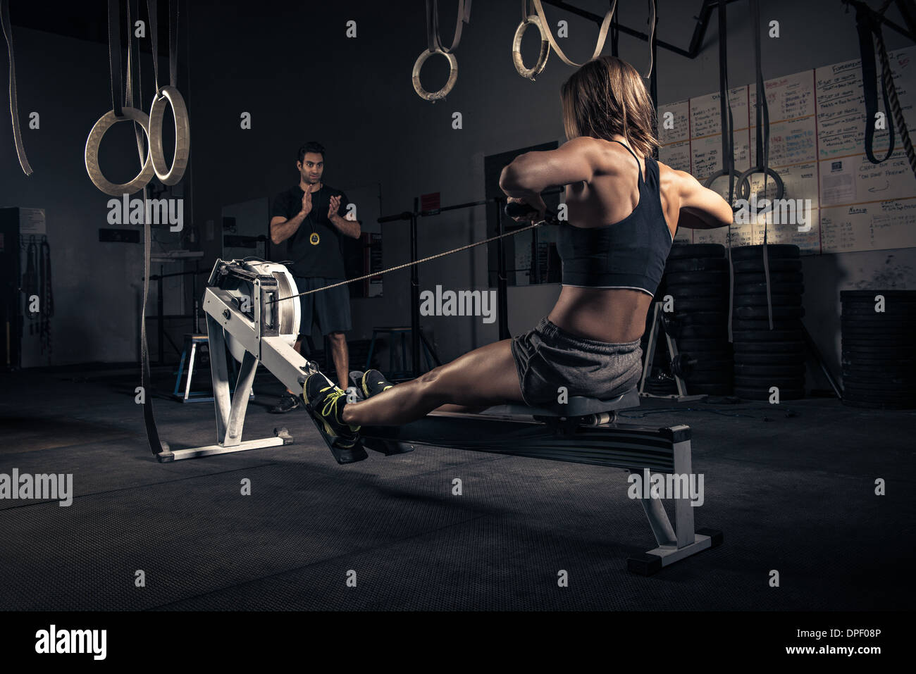 Woman using rowing machine in gym Stock Photo - Alamy