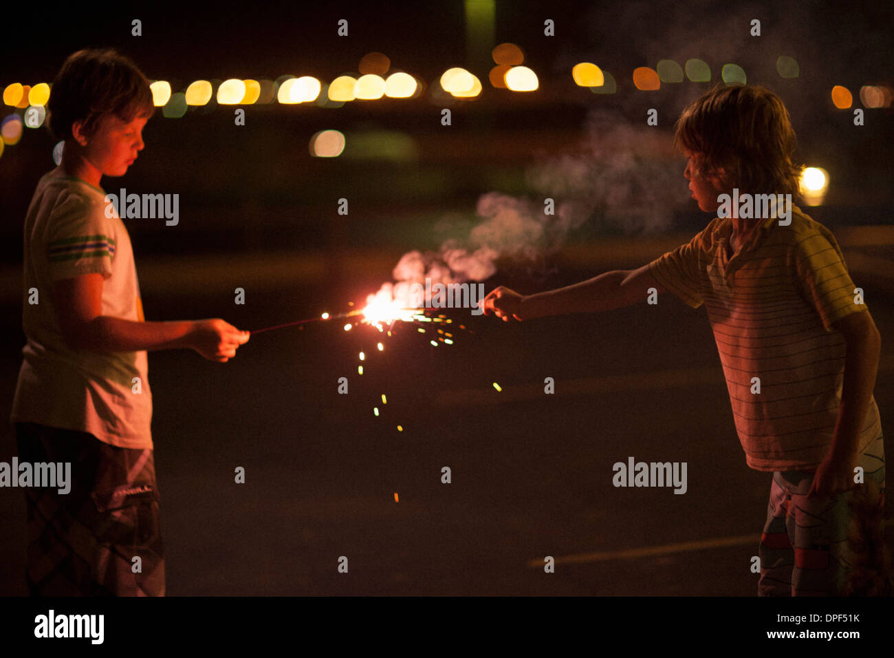 Two boys playing with sparklers on 4th July Stock Photo - Alamy