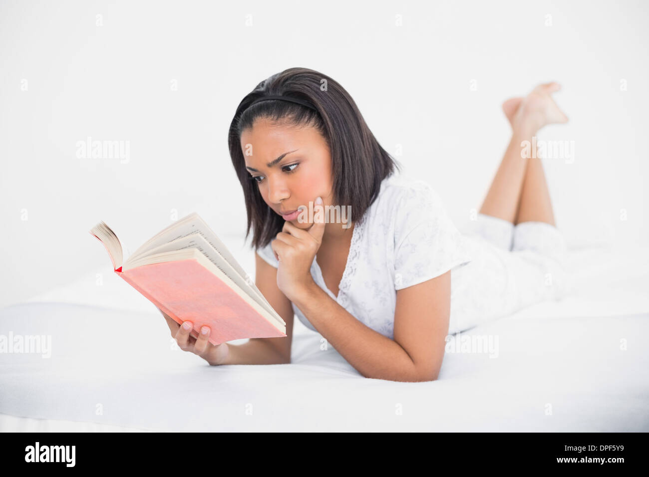 Focused young dark haired model reading a book Stock Photo - Alamy