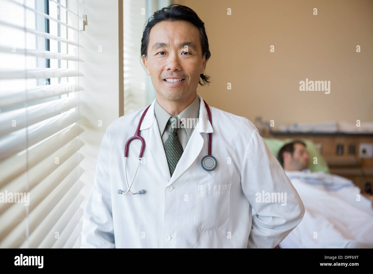 Confident Doctor With Patient At Hospital Room Stock Photo - Alamy