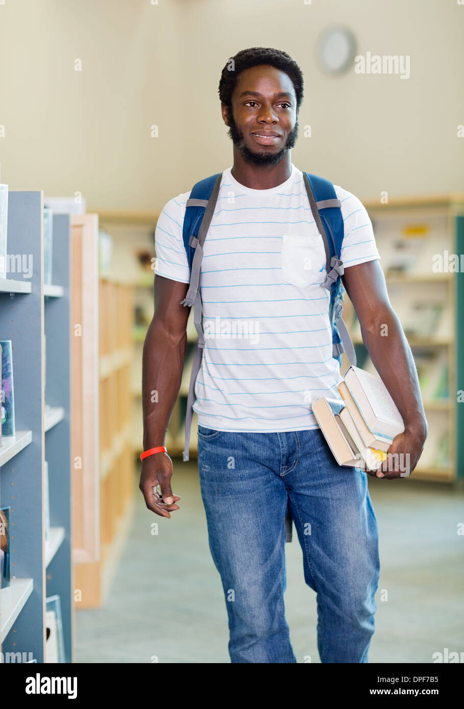 Student With Books Looking Away In Library Stock Photo - Alamy
