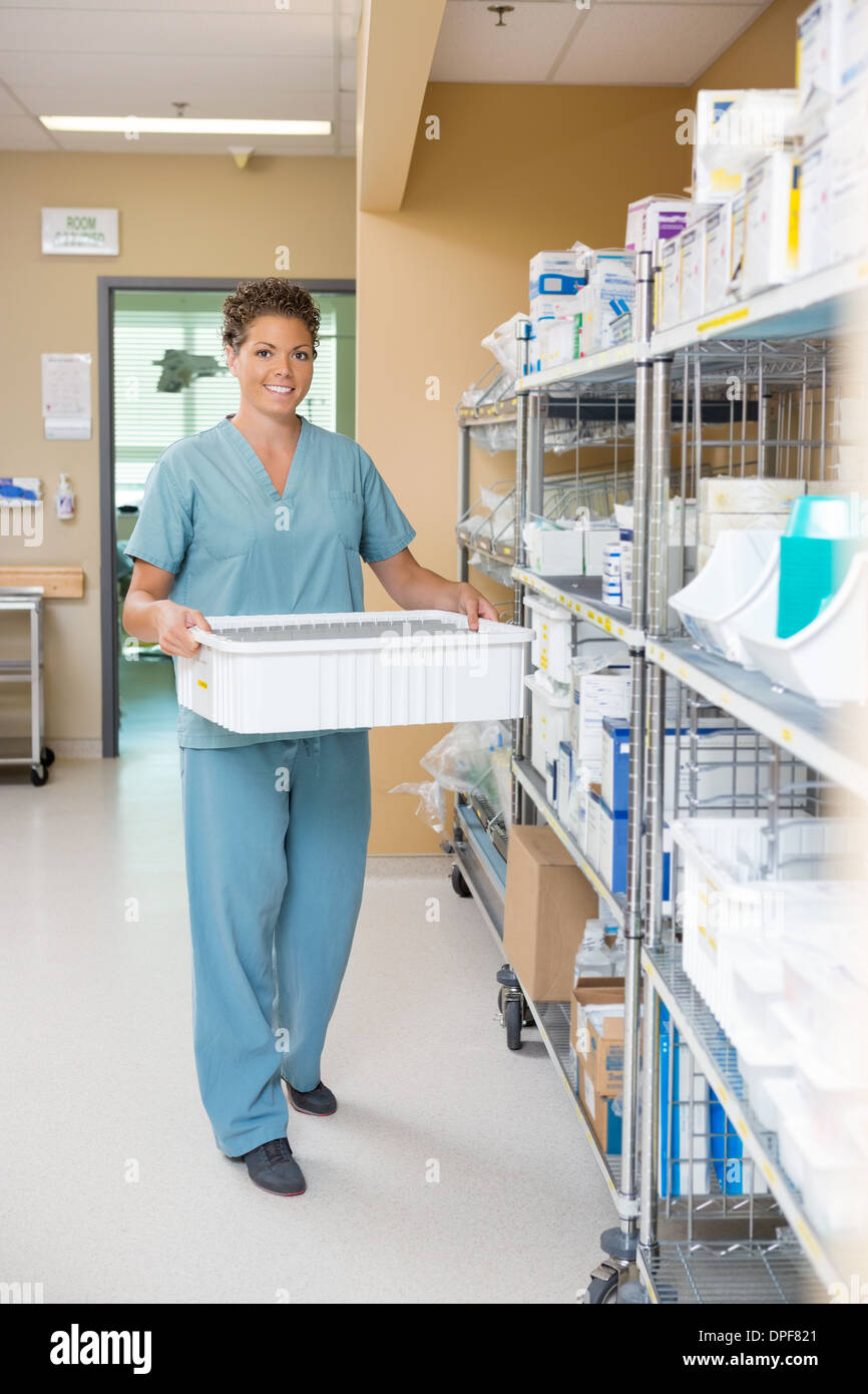 Nurse Carrying Container In Hospital Storage Room Stock Photo - Alamy