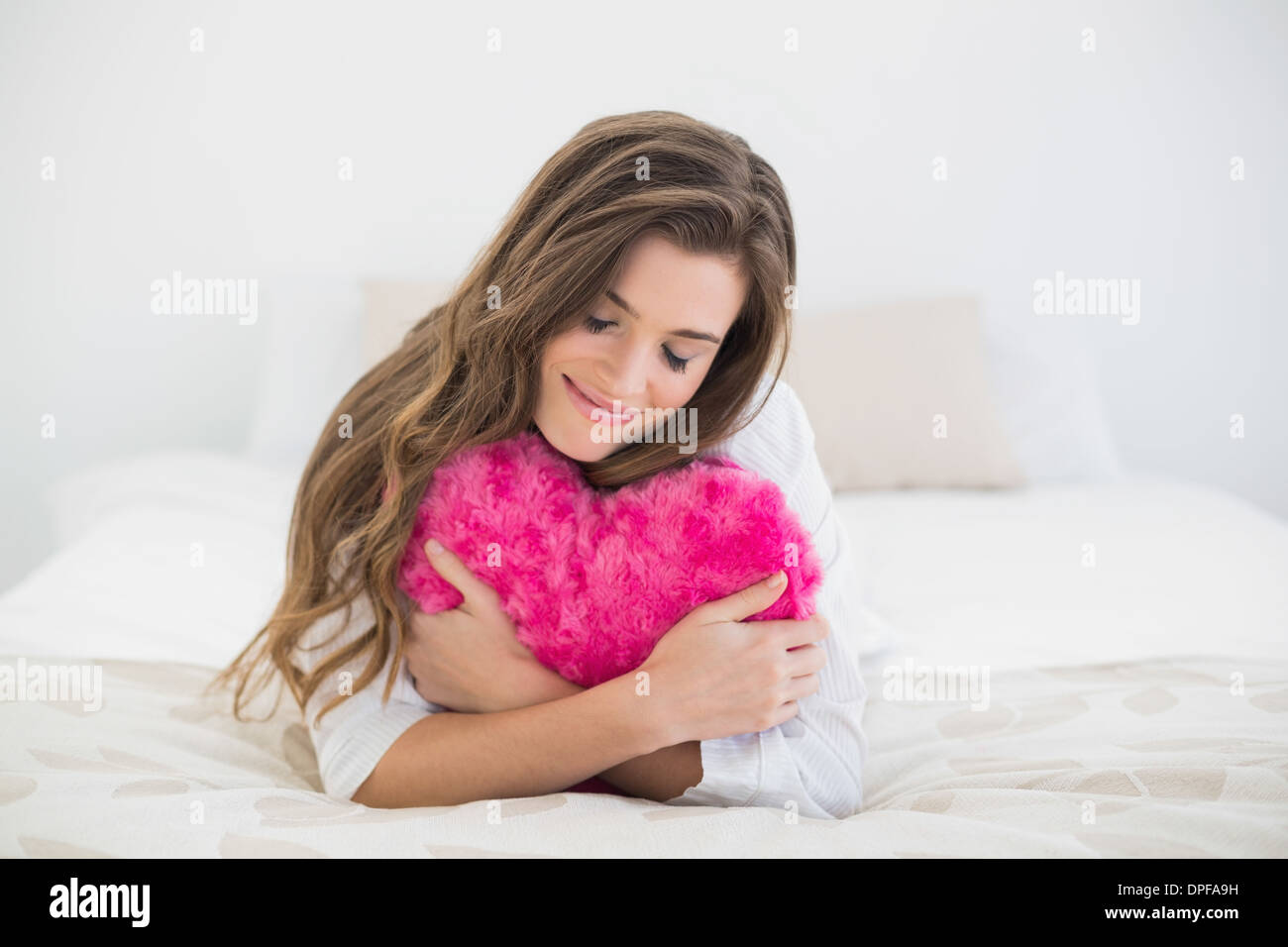 Happy woman hugging heart pillow hi-res stock photography and images ...