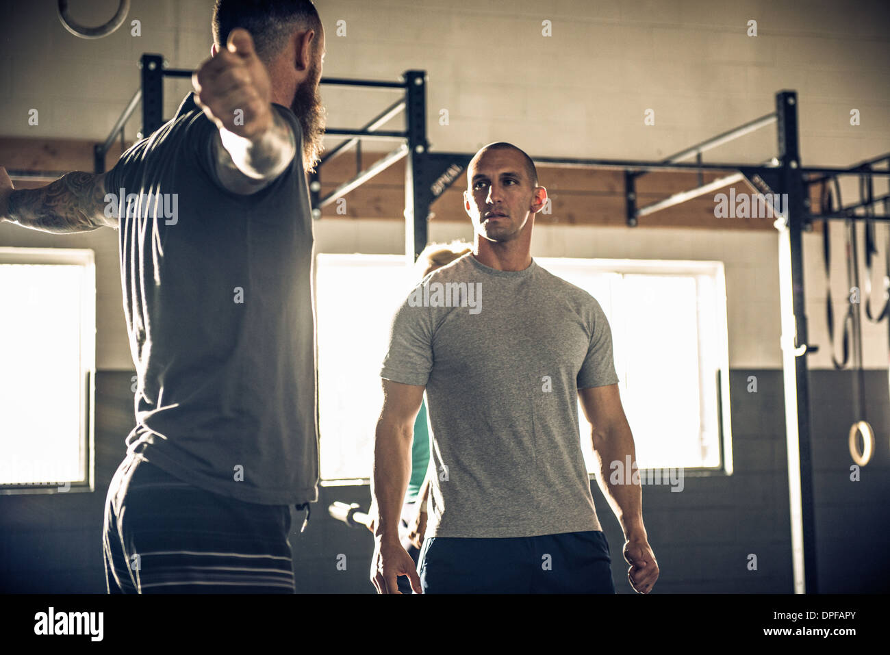Personal trainer working with client in gym Stock Photo - Alamy