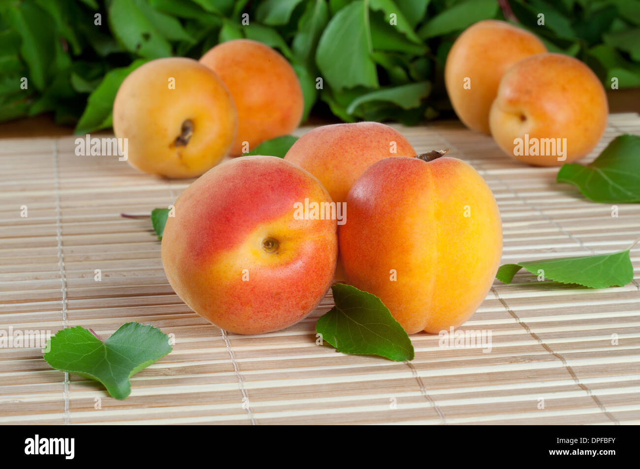 Bright yellow apricot with leaves on wooden background Stock Photo - Alamy