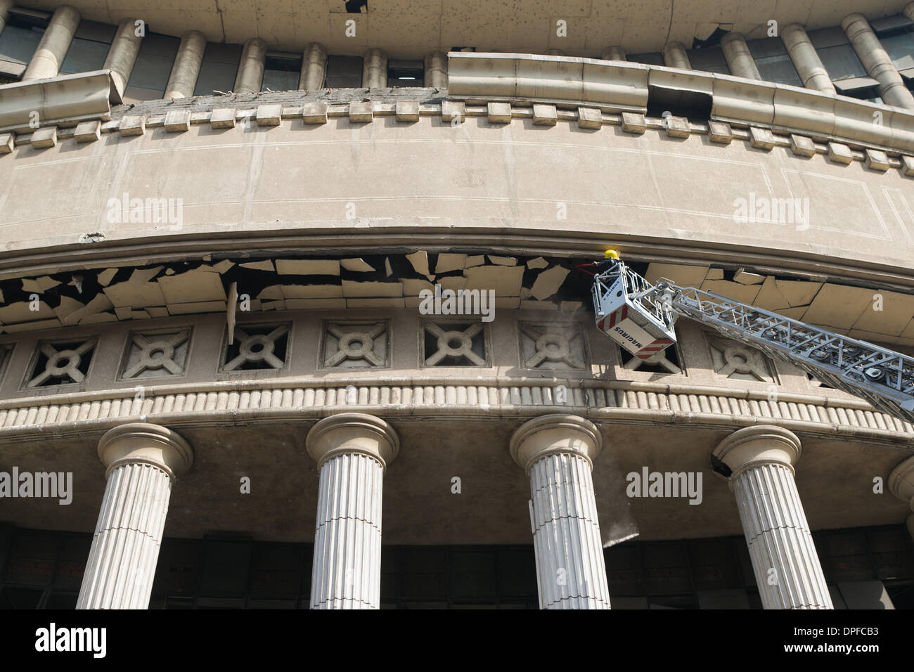 Cairo, Egypt. 14th Jan, 2014. A firefighter dismantle the facade ...