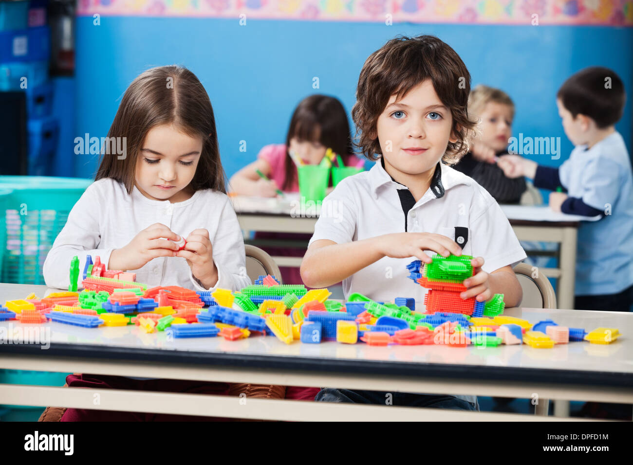 Boy With Female Friend Playing Blocks In Kindergarten Stock Photo - Alamy