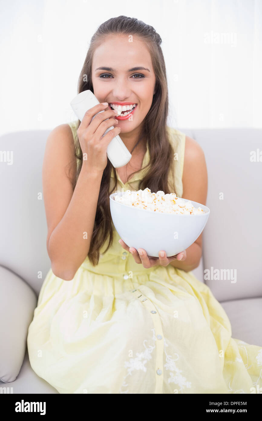 Laughing young brunette eating popcorn Stock Photo - Alamy